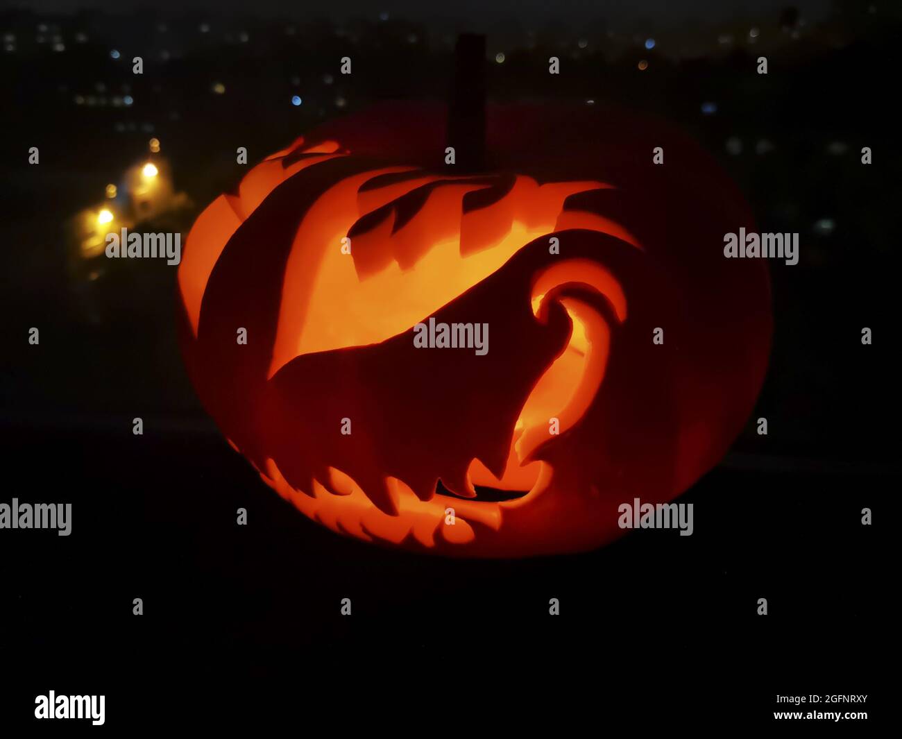 Illuminated, smiling, large, hand made pumpkin with eyes like fire ...