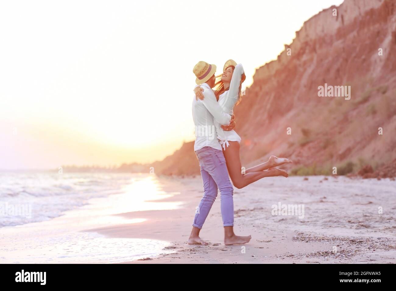 Young happy couple on beach on cliff background Stock Photo - Alamy