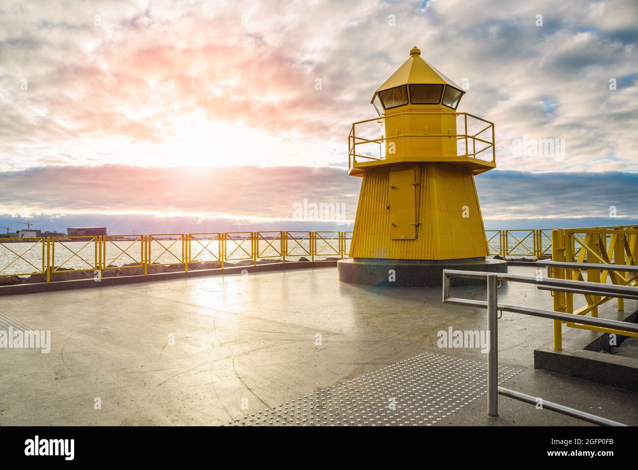 Yellow steel lighthouse under cloudy sky at sunset Stock Photo - Alamy