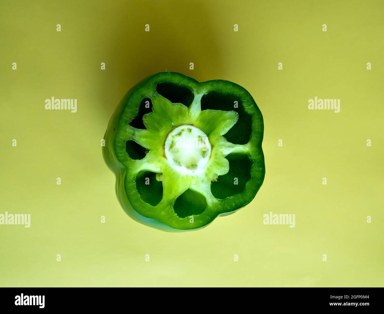 red pepper cross-section with visible seeds, on yellow background, top ...
