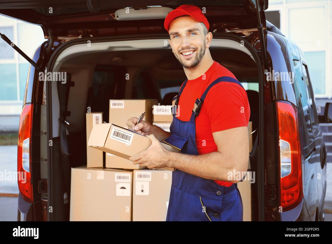 Delivery man checking packages Stock Photo - Alamy