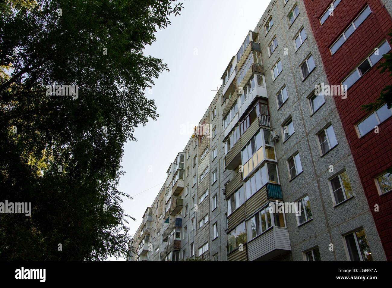 A painter paints the facade of the upper floors of a nine-story ...