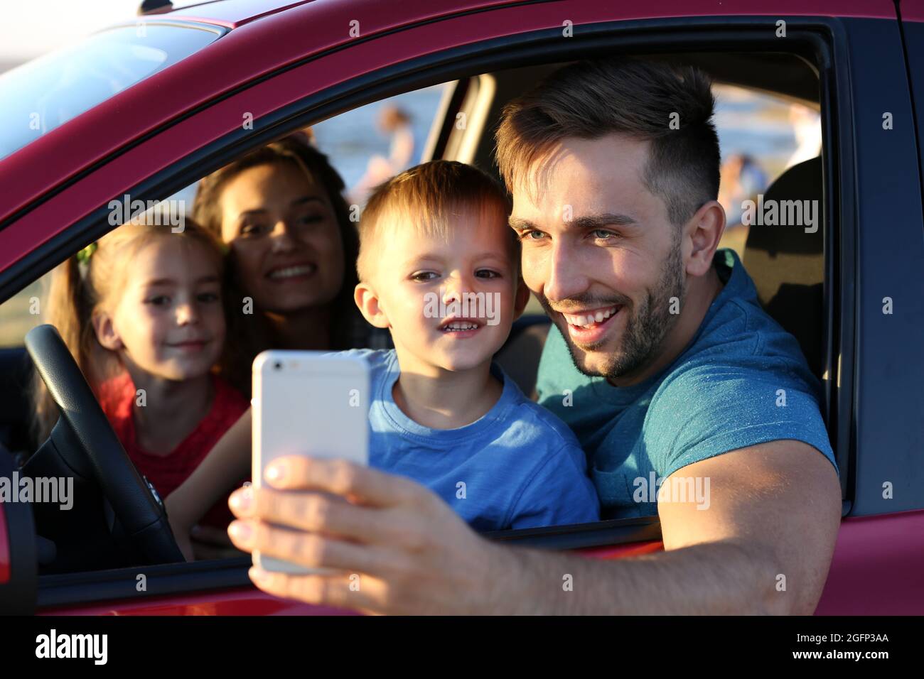 Parents with kids taking photo in car Stock Photo - Alamy