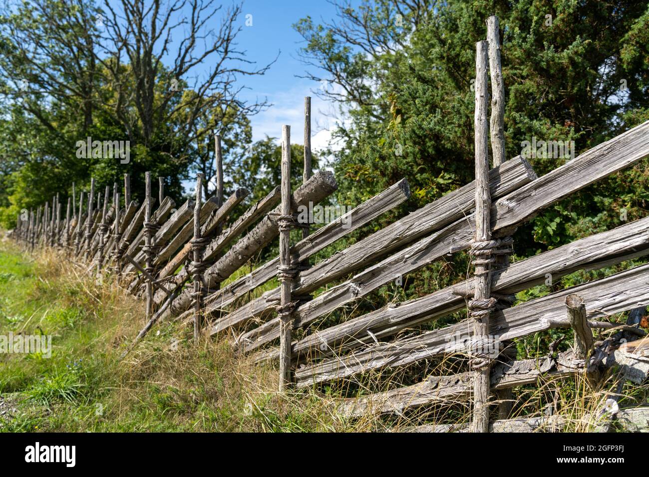 A traditional wooden fence made with rough logs and boards in the ...