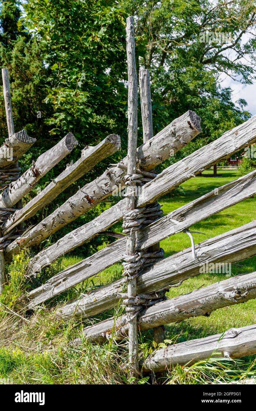 A traditional wooden fence made with rough logs and boards in the ...
