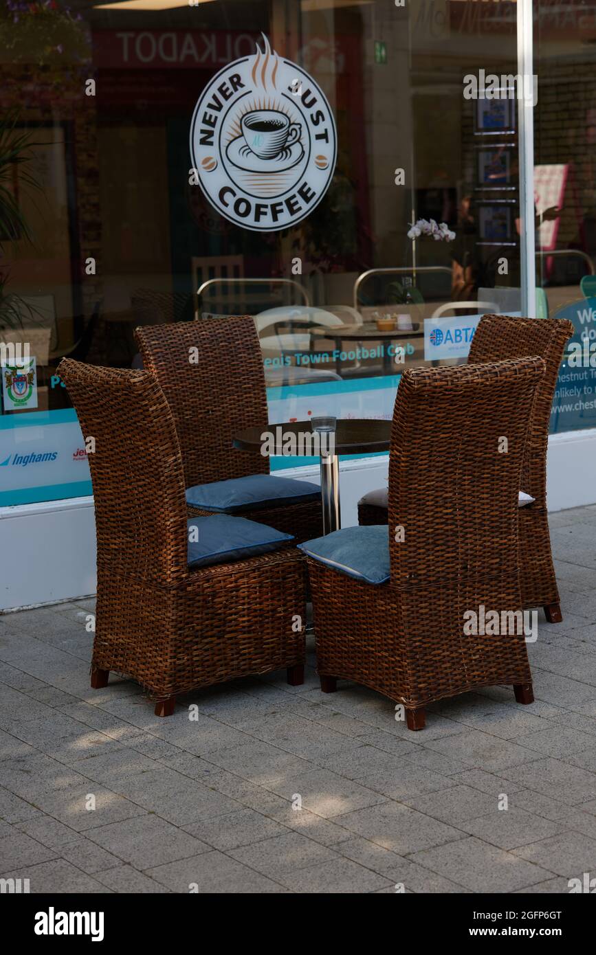 Four rotan chairs around a round table Stock Photo - Alamy