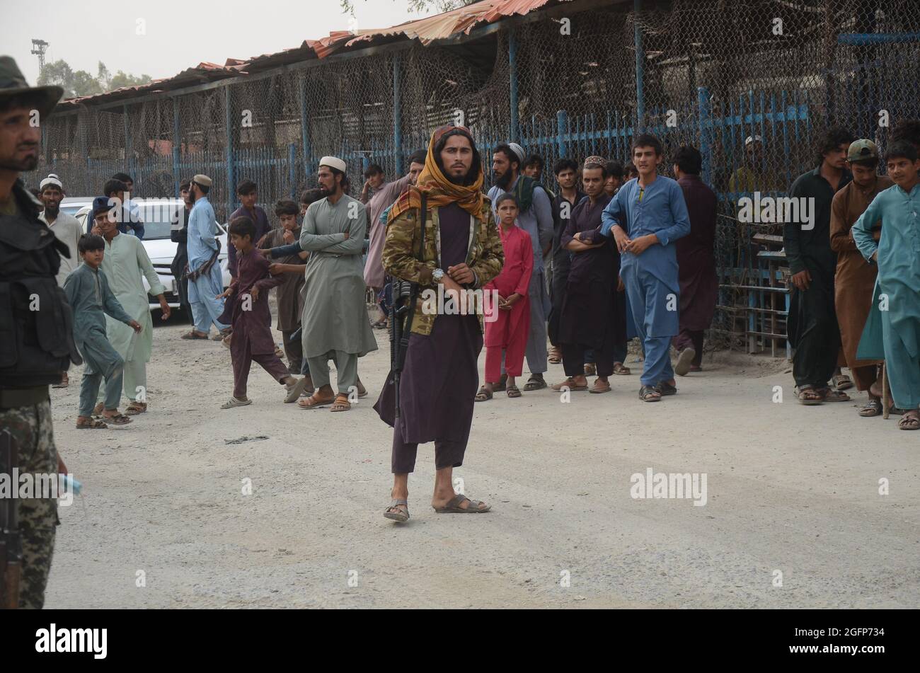 Taliban fighters stand guard on their side at a border crossing point ...