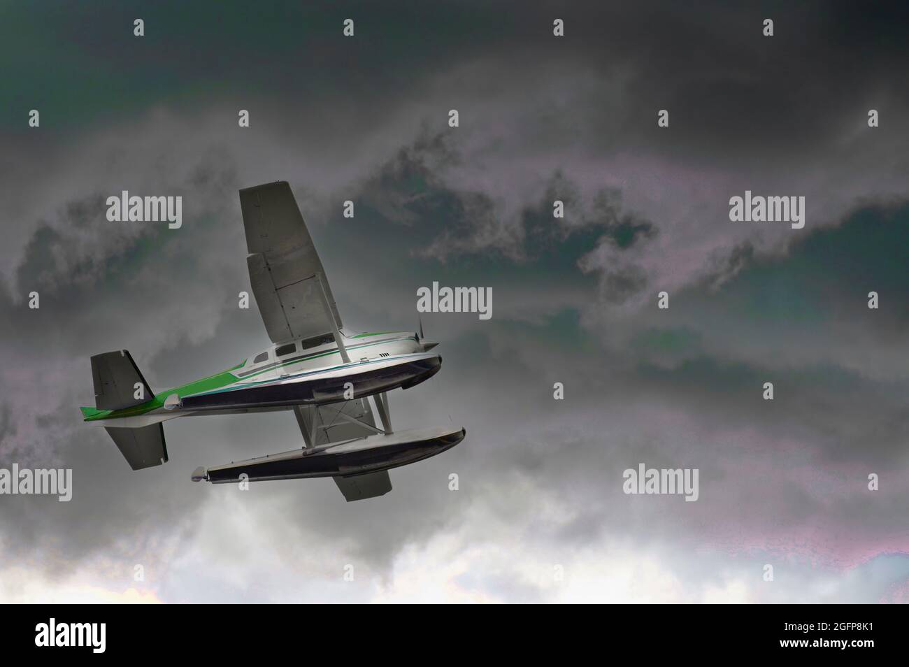 Alaskan single engine float plane flying in dark stormy sky in Akaska ...