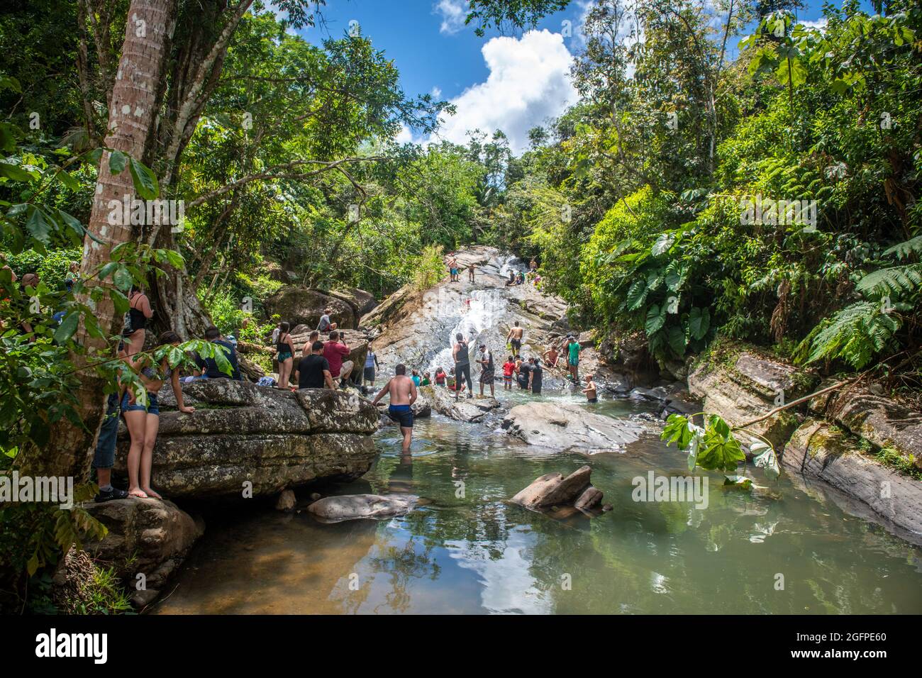 People gathered around the bottom of a natural water slide - Puerto ...