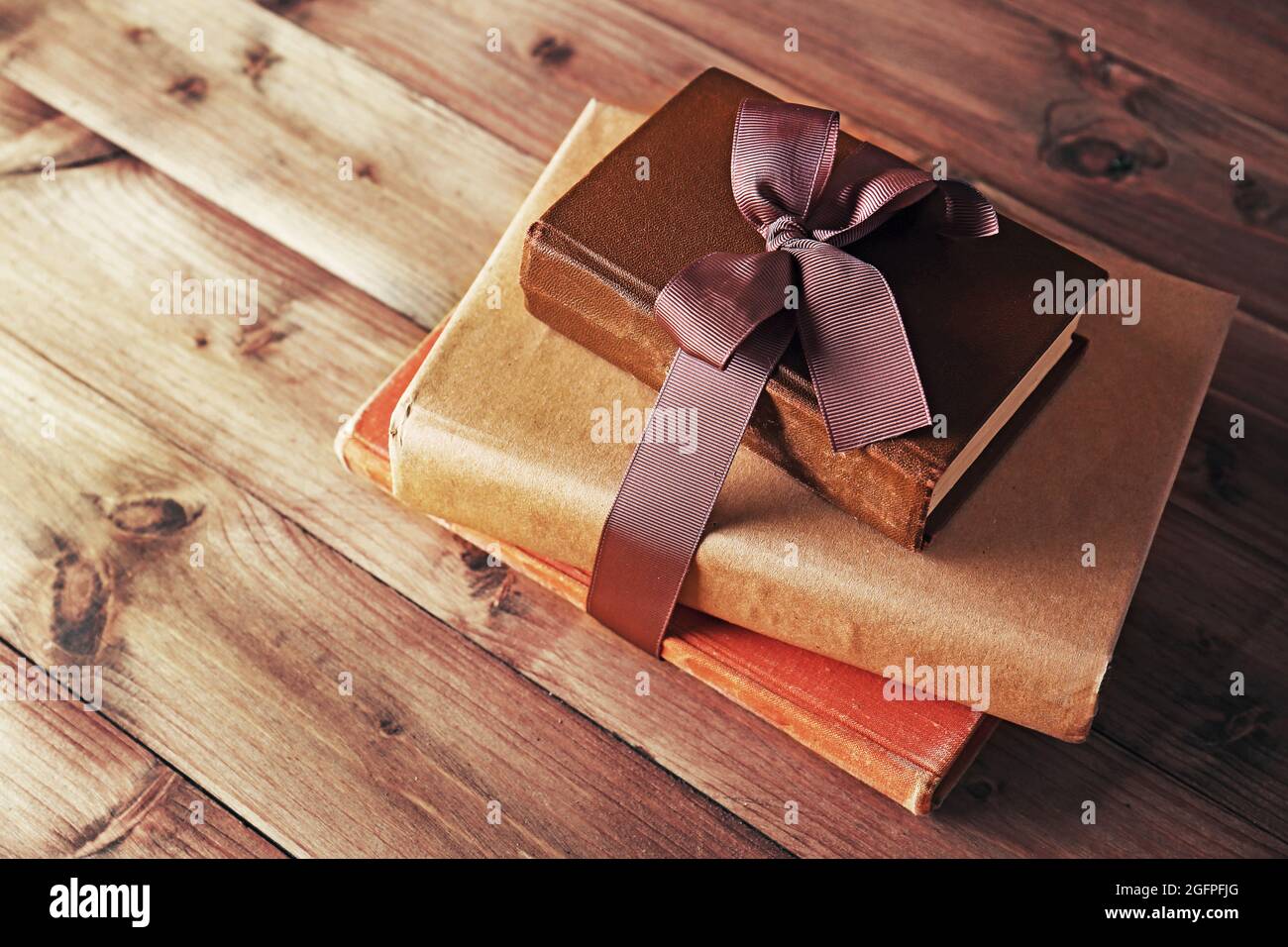 Old books tied in ribbon on wooden background Stock Photo - Alamy