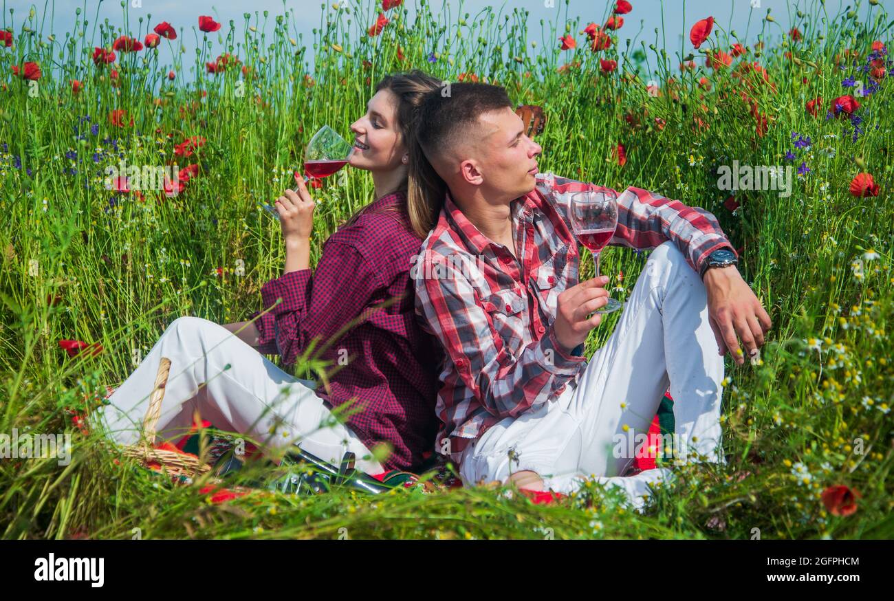 couple in love of man and woman drink red wine in summer poppy flower ...