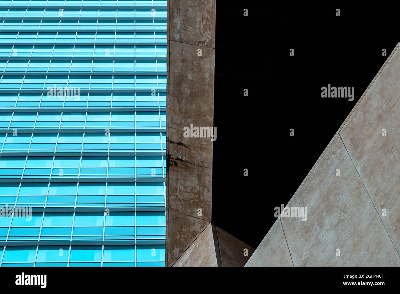 Grid of blue and teal glass windows on building exterior contrasting ...