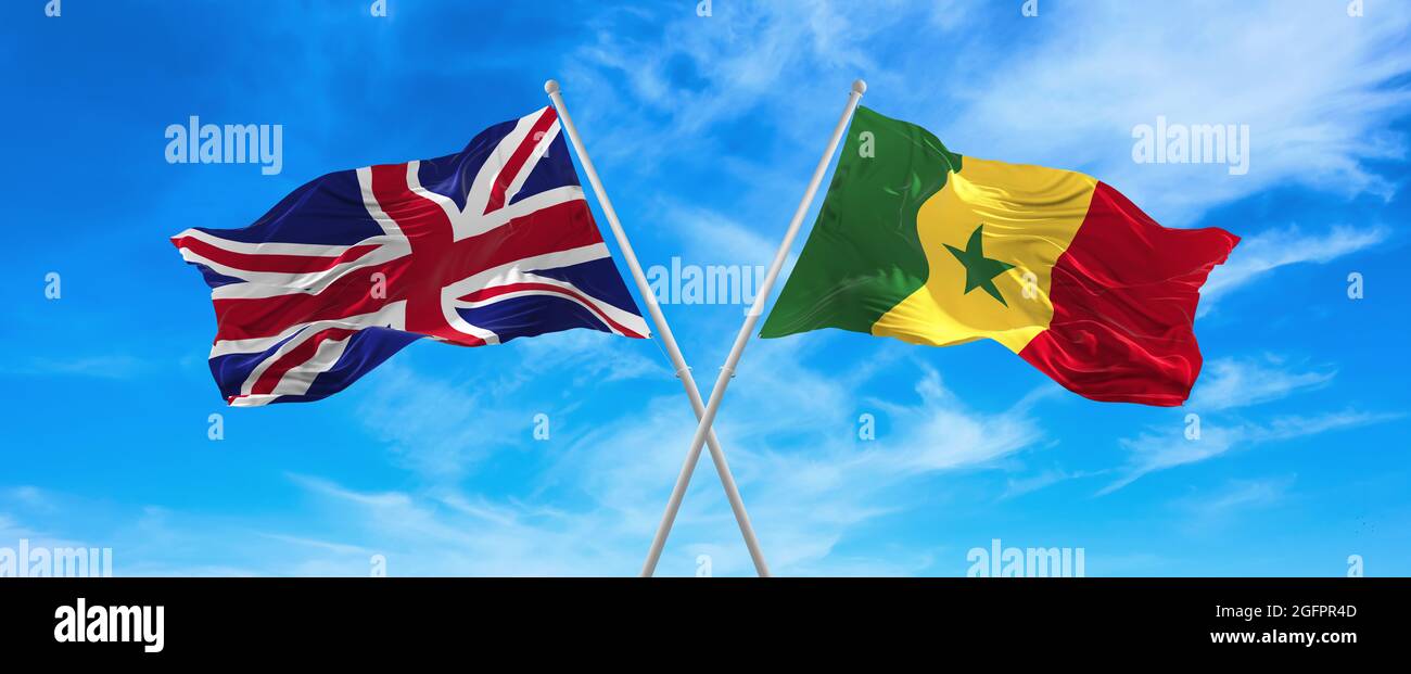 flags of great Britain and Senegal waving in the wind on flagpoles ...