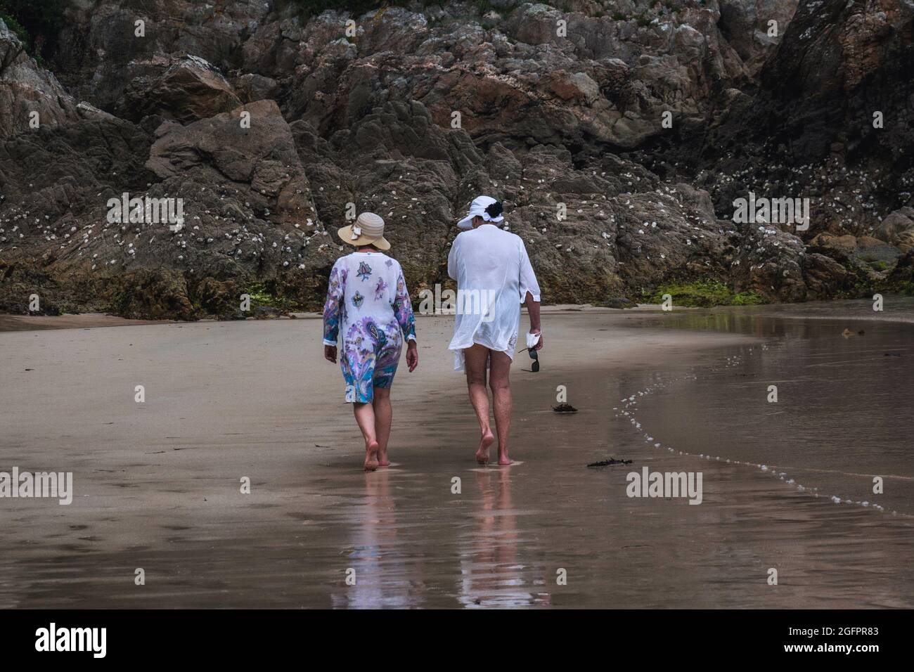 Shot of an old couple walking on the Xilloi beach in front of rocky ...