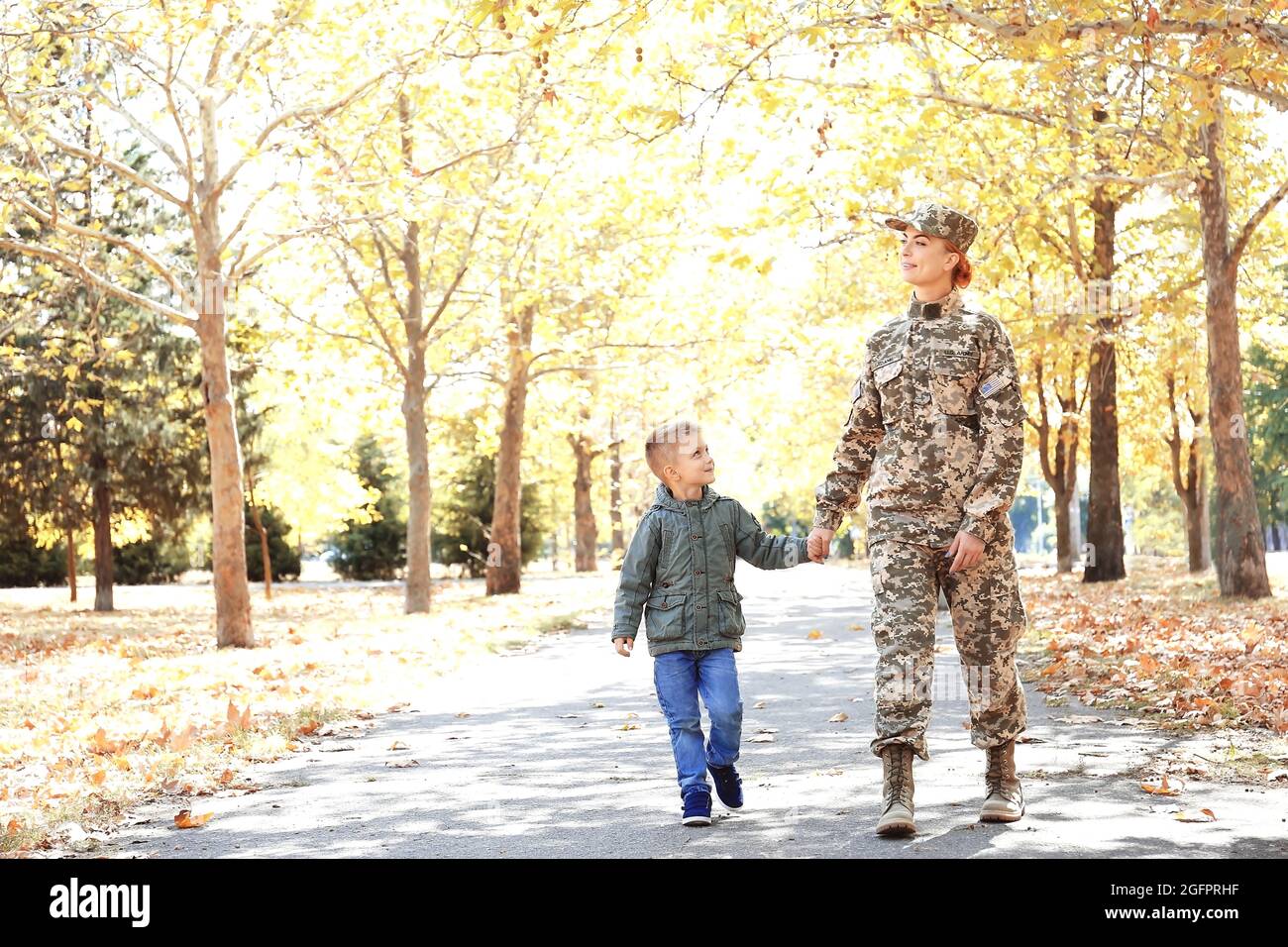Mother soldier and little kid walking in the park Stock Photo - Alamy