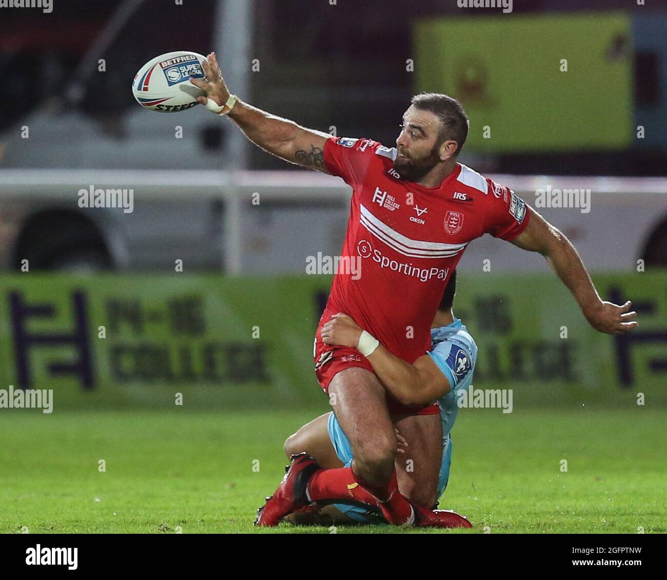 Kane Linnett (12) of Hull KR gets is pass away before the tackle is ...