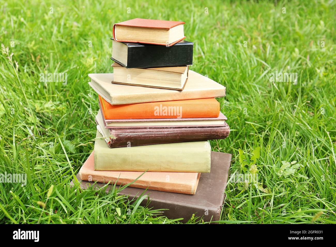 Pile of books on green grass Stock Photo - Alamy