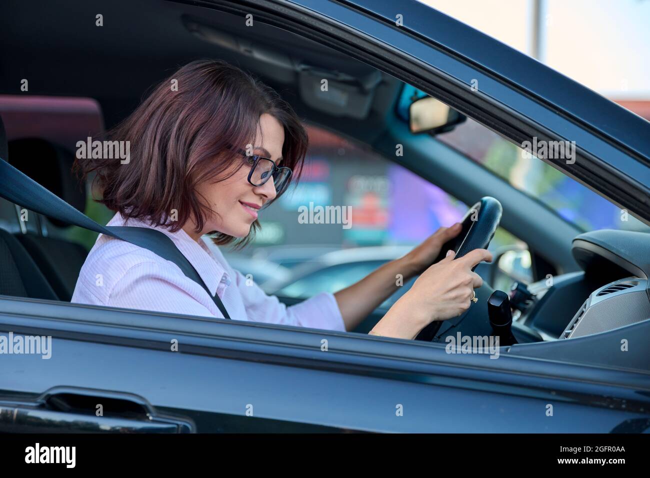 Middle-aged beautiful woman driver driving a car Stock Photo - Alamy