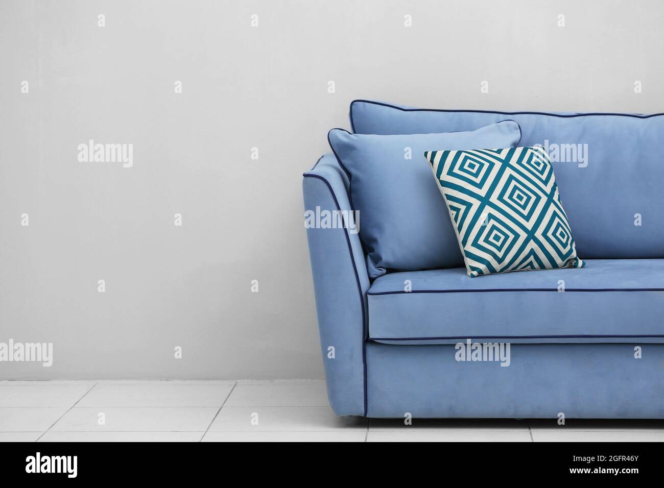Modern couch on light wall background Stock Photo - Alamy
