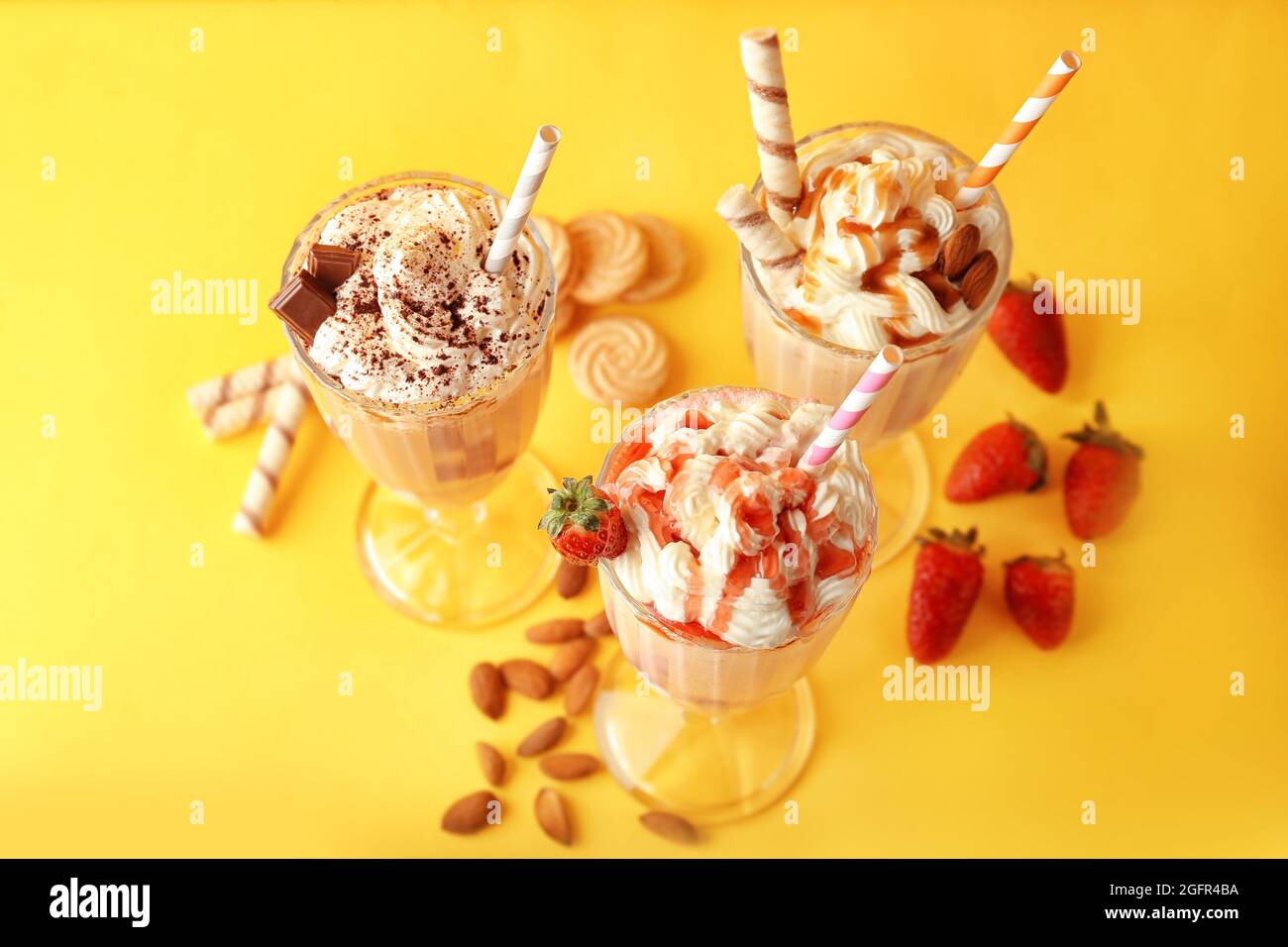 Delicious milkshakes on yellow background Stock Photo - Alamy