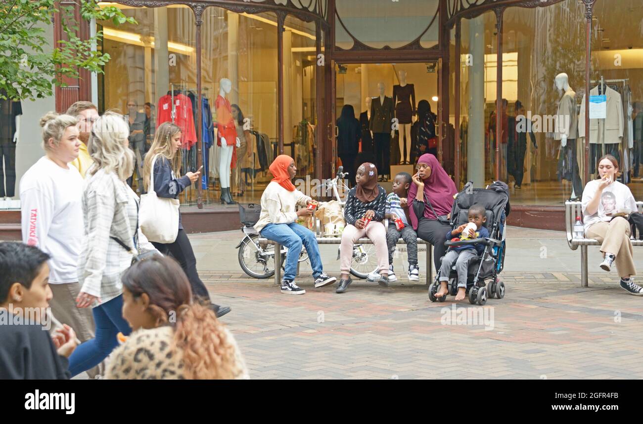 African family on a bench in among crowds Stock Photo - Alamy
