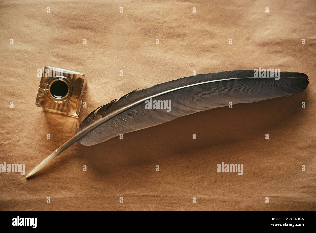 Feather pen and inkwell on paper background Stock Photo - Alamy