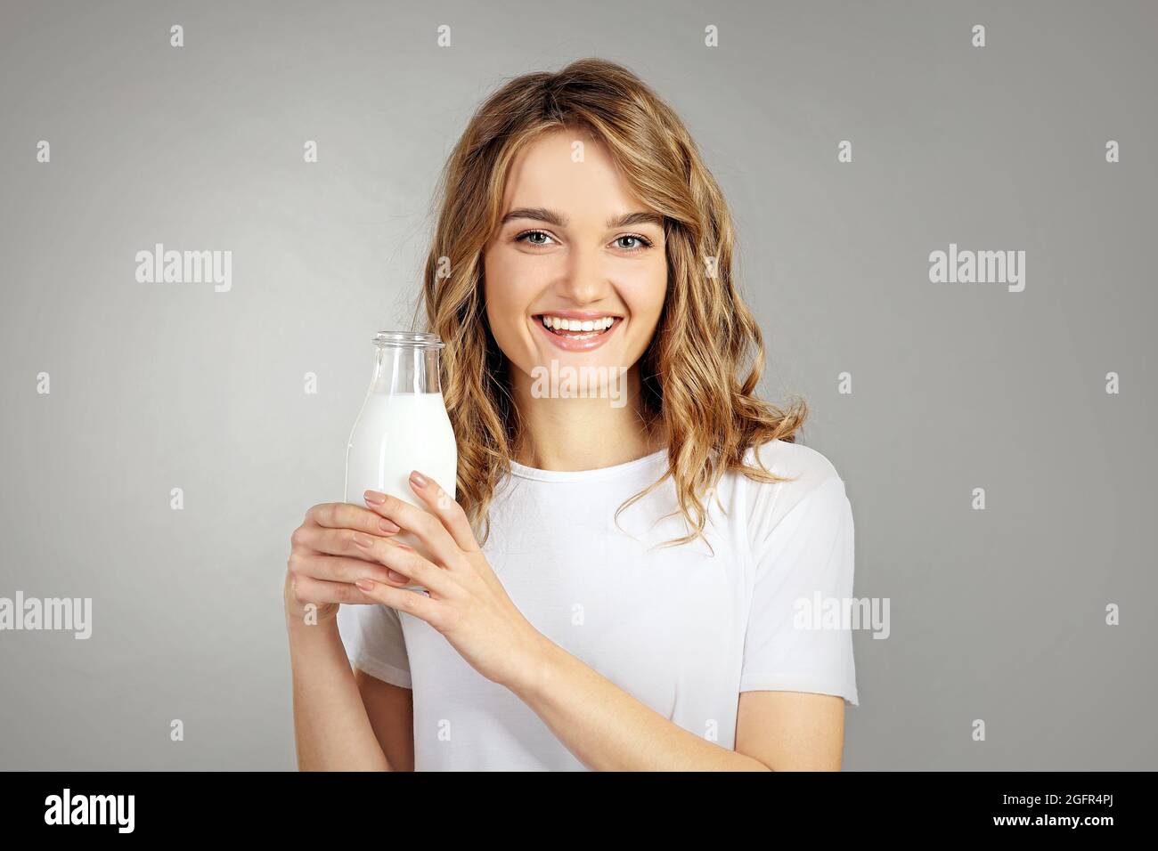 Beautiful young woman with bottle of milk Stock Photo - Alamy