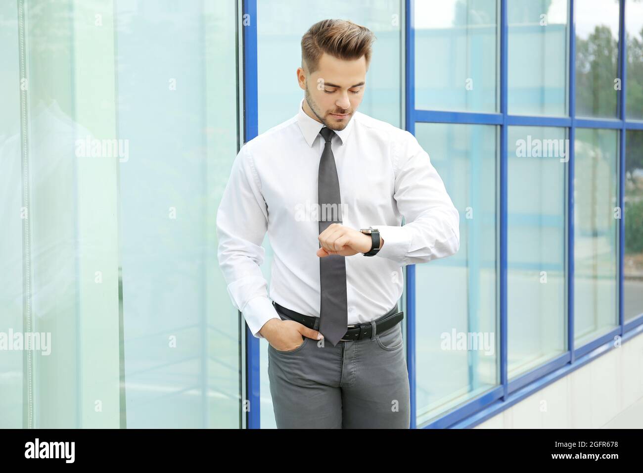 Handsome man on windows background Stock Photo - Alamy