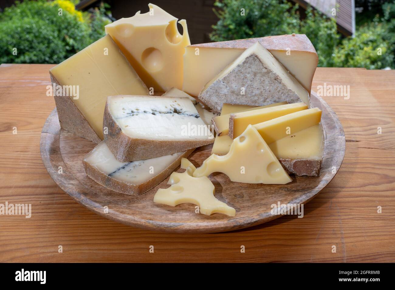 Cheese collection, wooden board with French cheeses comte, beaufort ...