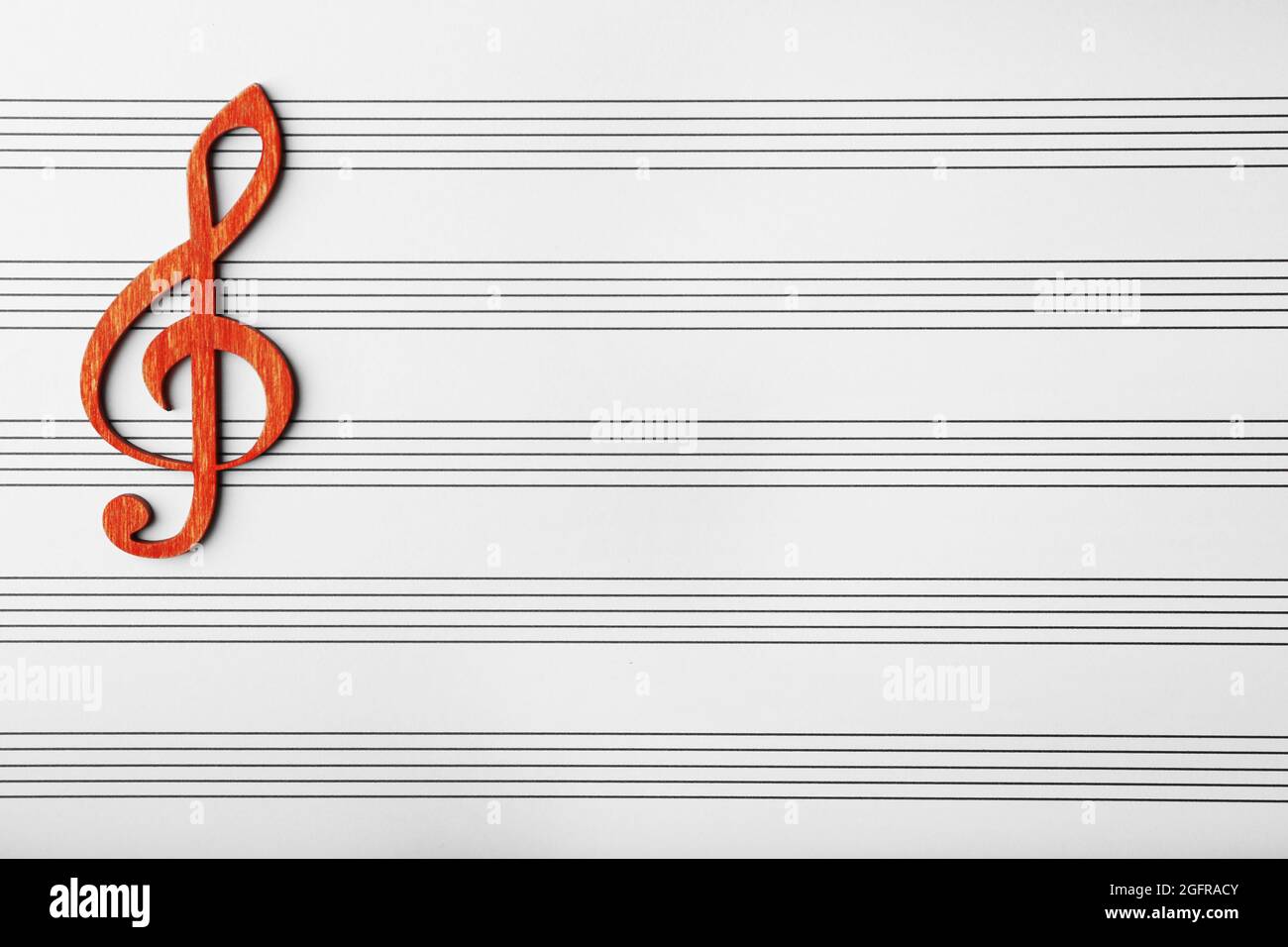 Wooden musical clef on music sheet background Stock Photo - Alamy
