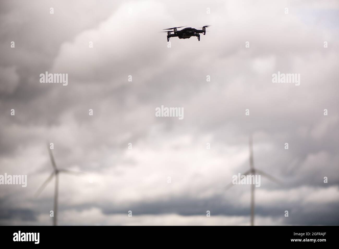 Black Drone Flying On A Farm Field Of Sustainable Wind Turbines In An ...