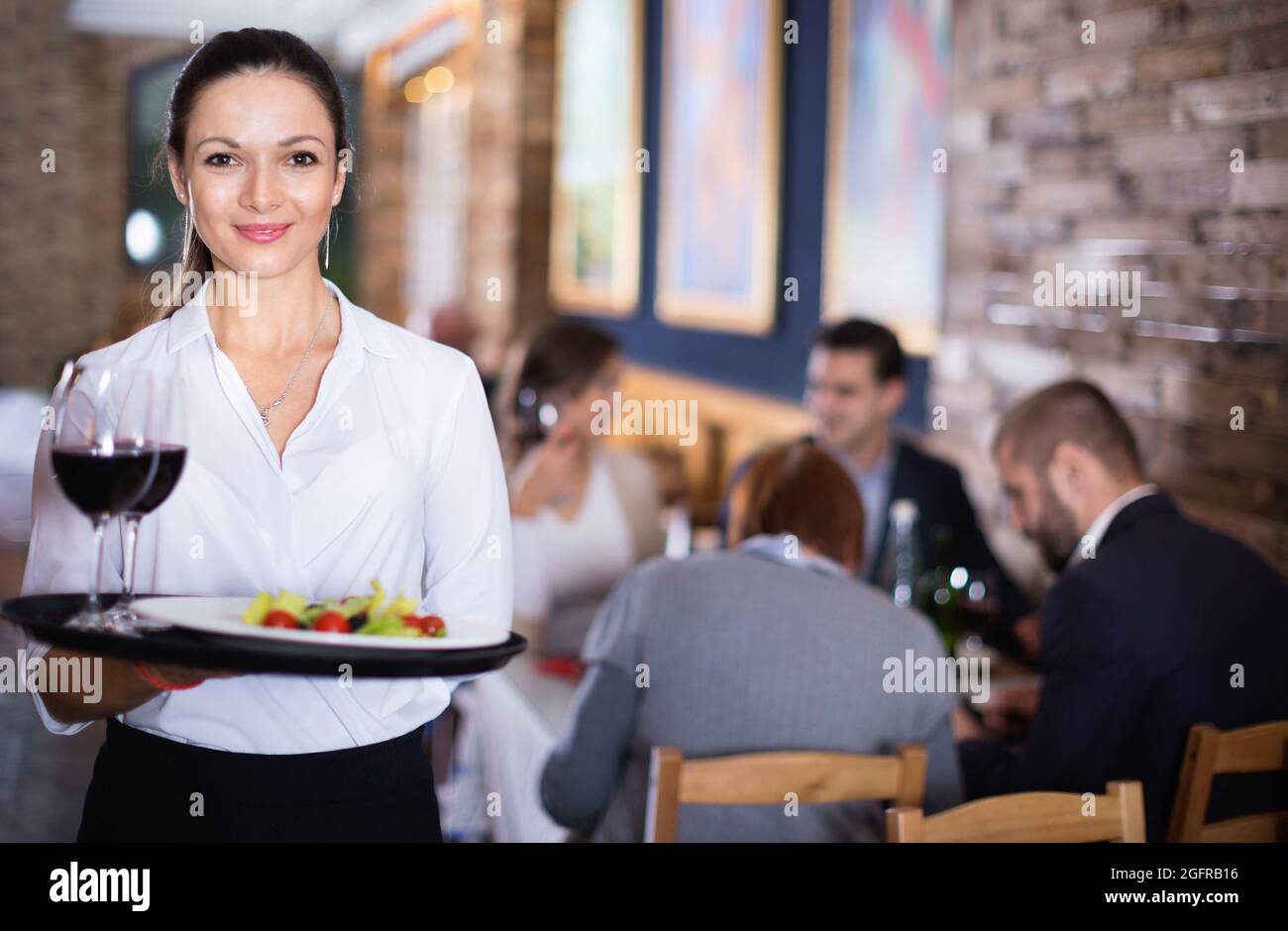 Professional waitress holding serving tray for restaurant guests Stock ...