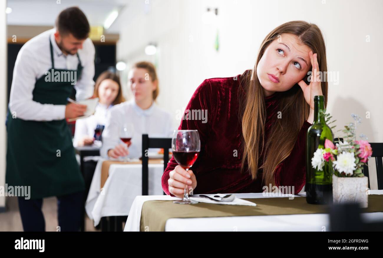 Young female is having dinner alone in the restaurante Stock Photo - Alamy