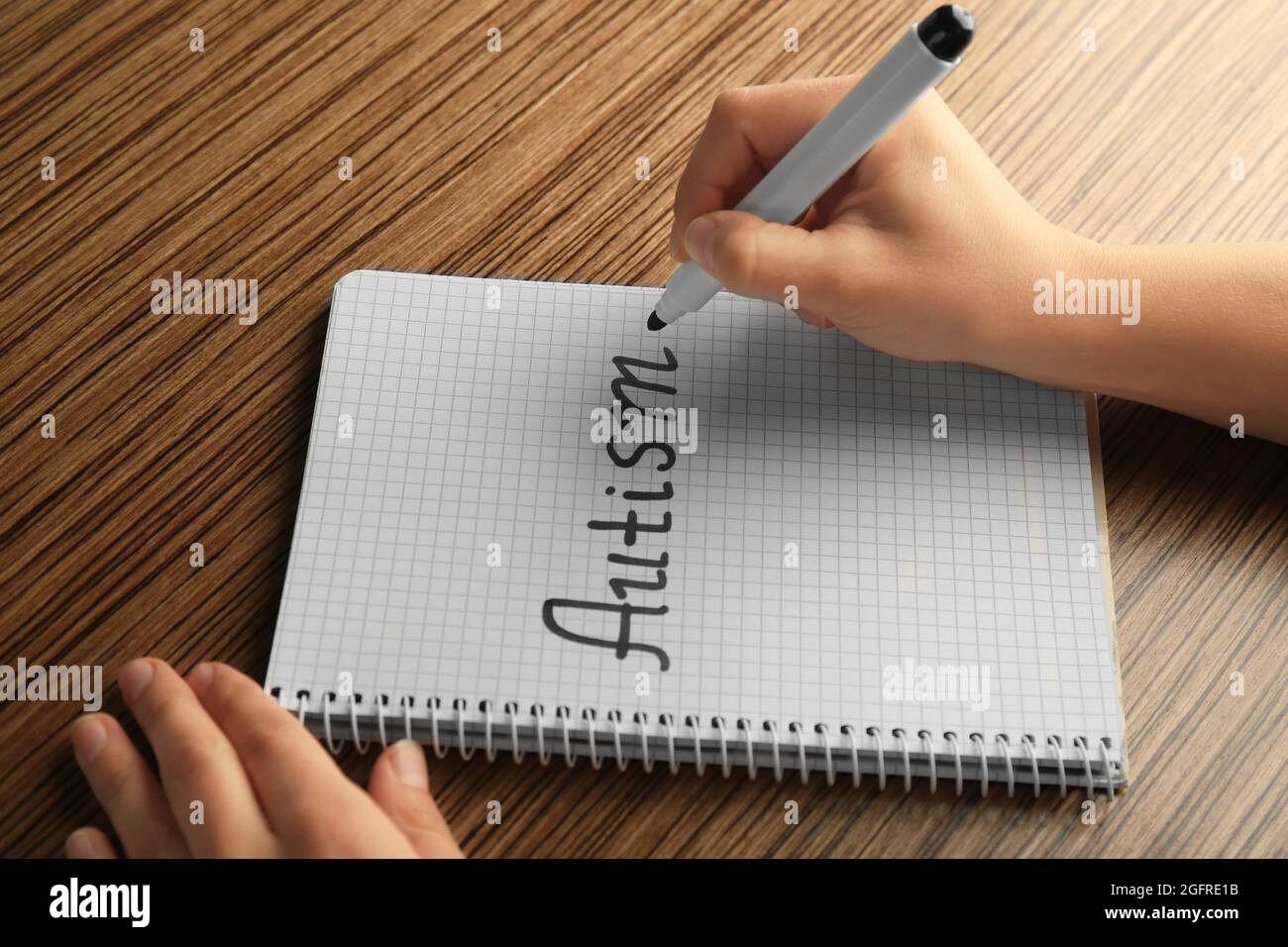 Human hands writing word AUTISM in notebook Stock Photo - Alamy