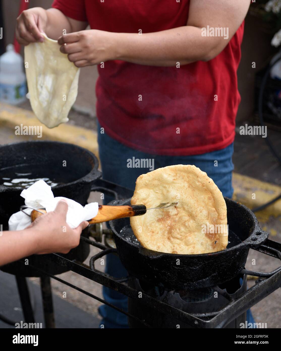Native American volunteer cooks make Indian tacos or Indian fry bread ...