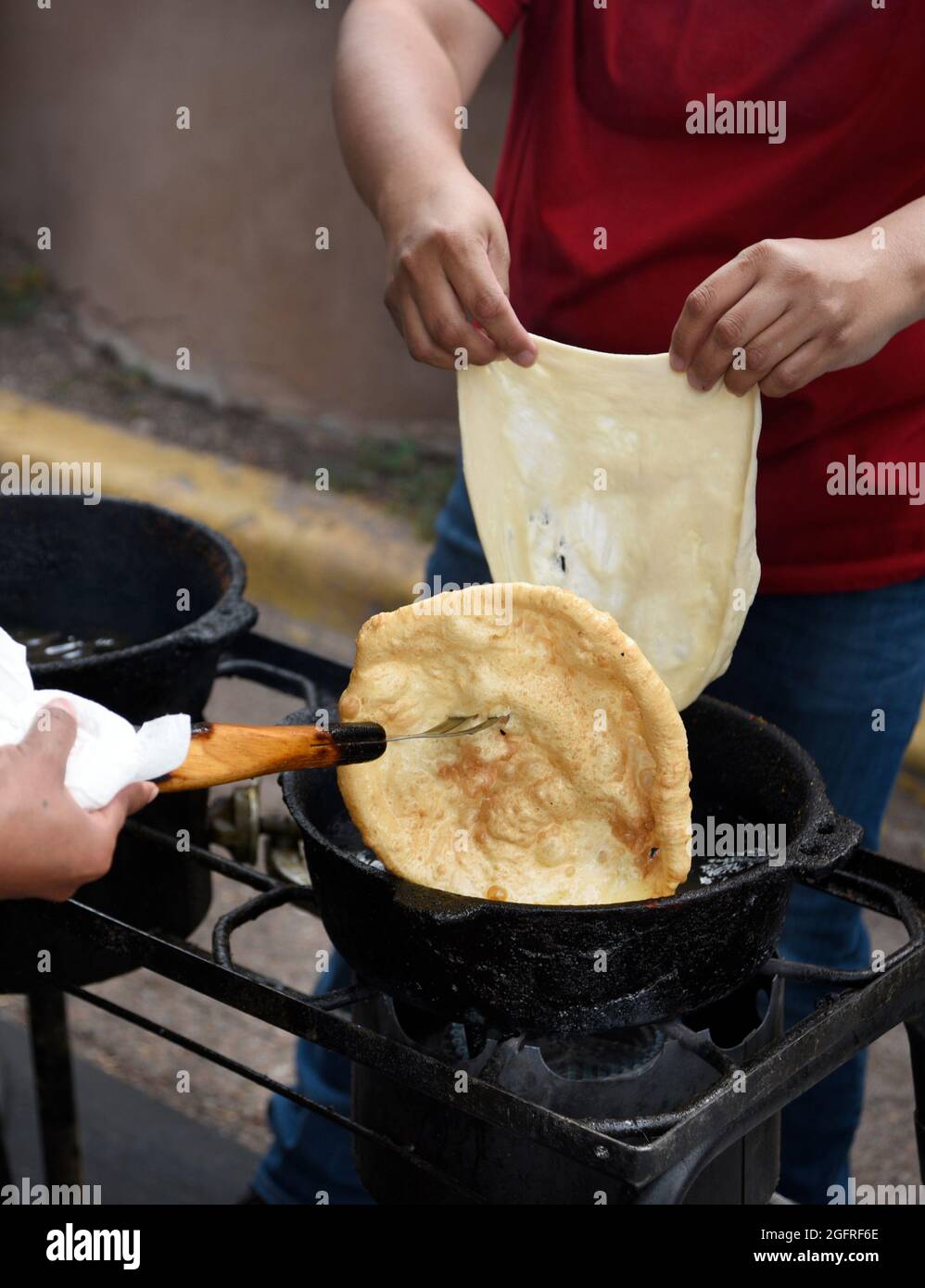 Native American volunteer cooks make Indian tacos or Indian fry bread ...