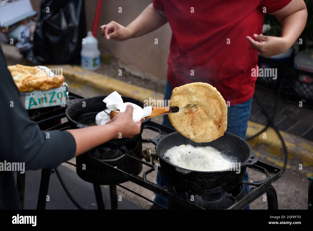 Native American volunteer cooks make Indian tacos or Indian fry bread ...