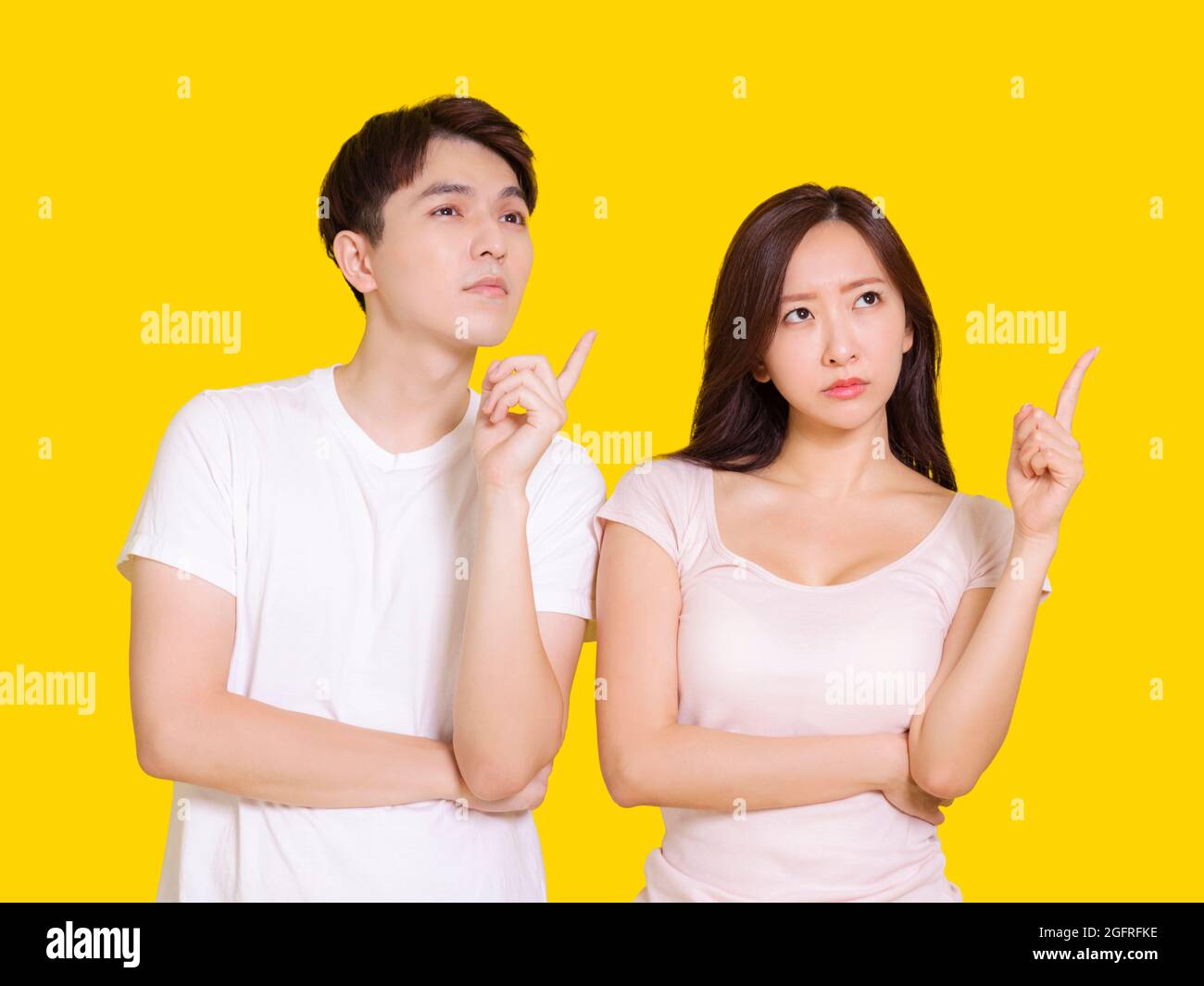 Young couple pointing upside.Isolated on yellow background Stock Photo ...