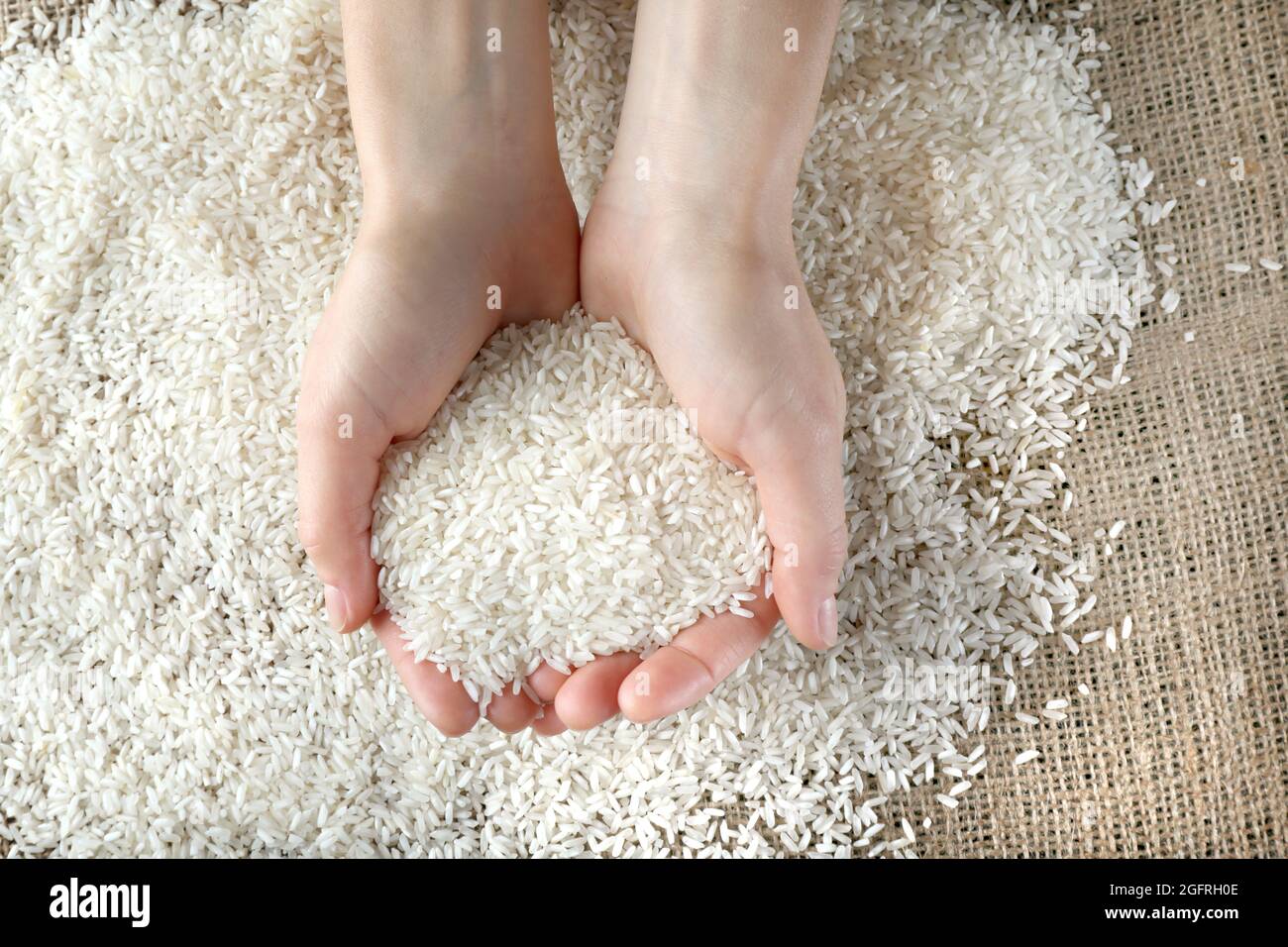 Female hands full of white rice closeup Stock Photo - Alamy