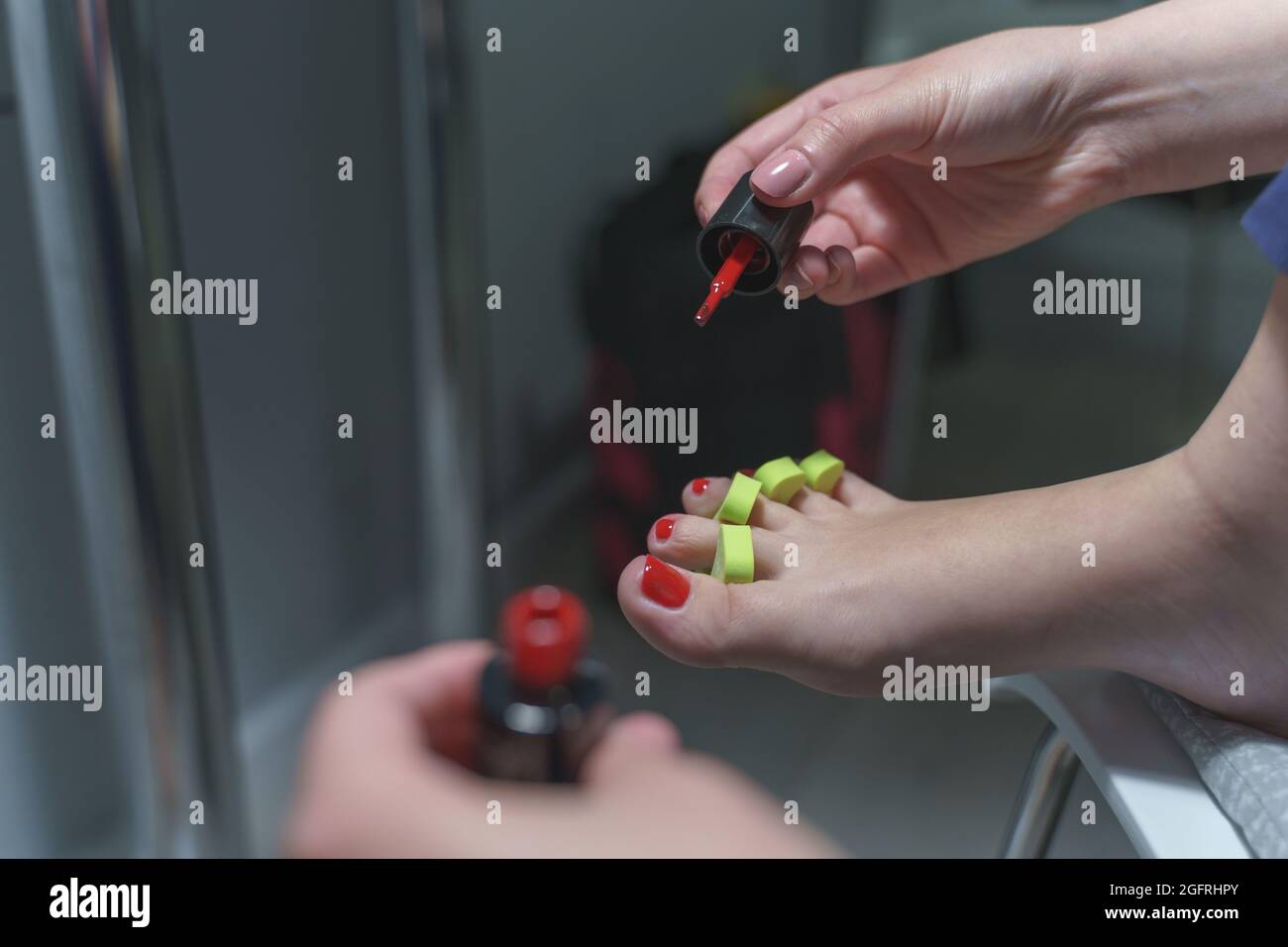Side view on hand applying gel lac on feet toes nails - Unknown woman ...