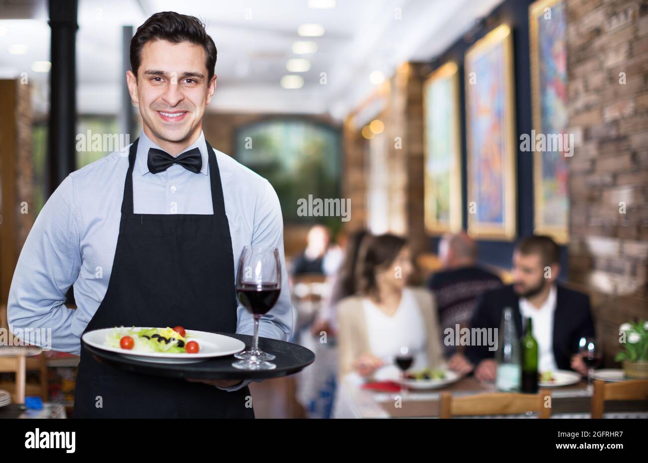 Smiling waiter with serving tray in restaurant Stock Photo - Alamy