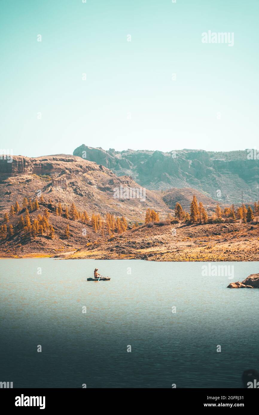 Beautiful vertical lake scape with a person kayaking in it Stock Photo - Alamy