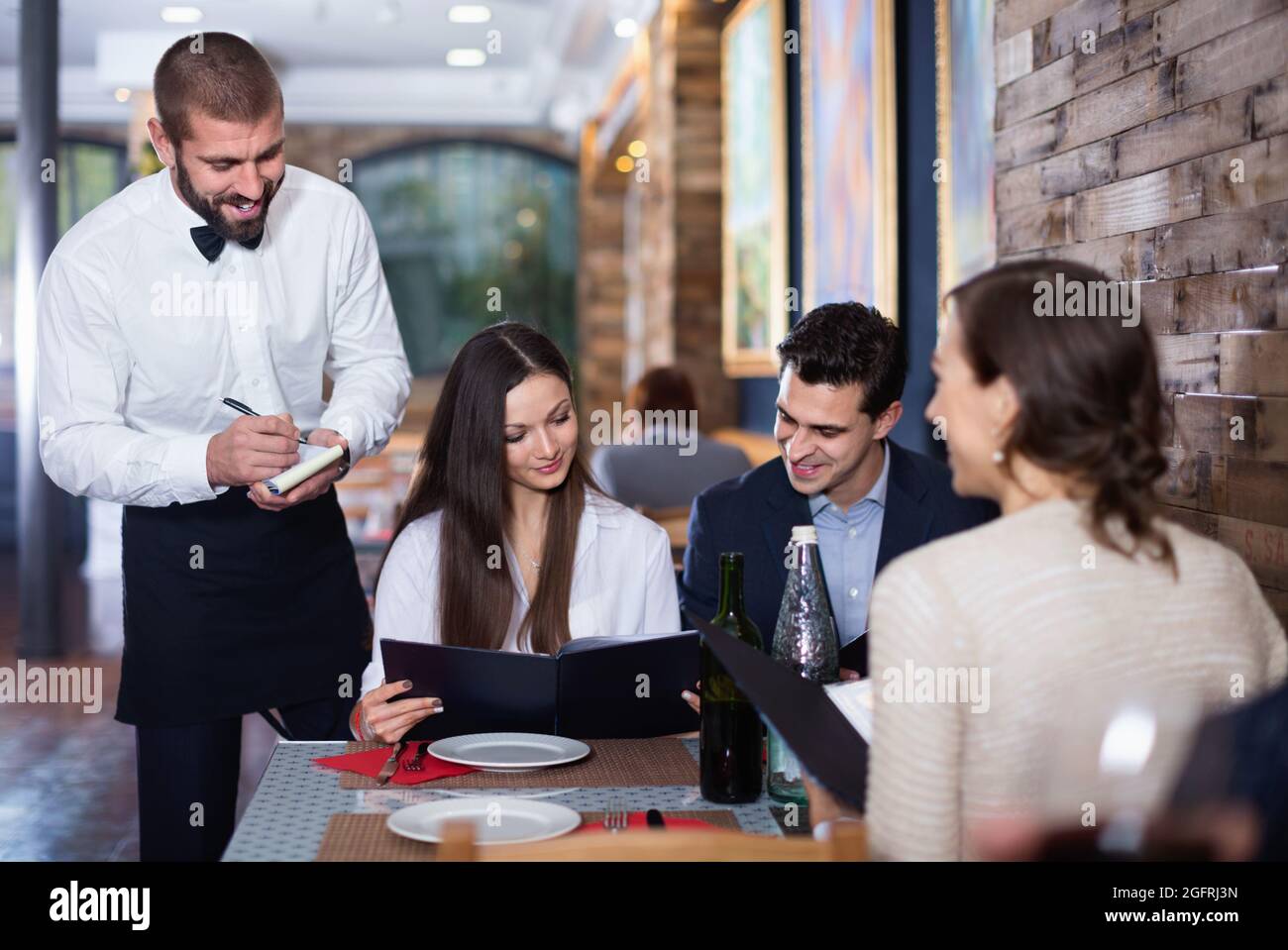 Friendly smiling waiter taking order hi-res stock photography and ...