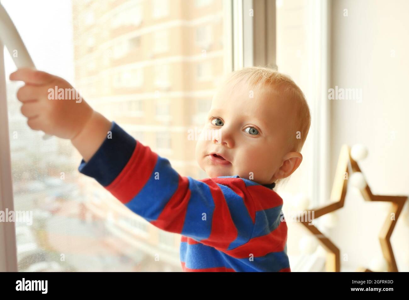 Cute little boy near window at home Stock Photo - Alamy