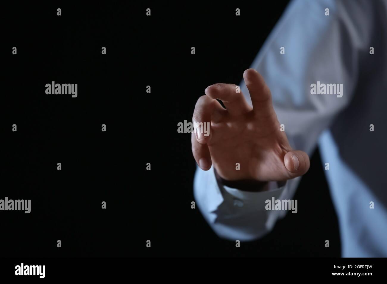 Businessman hand pointing, black background Stock Photo - Alamy