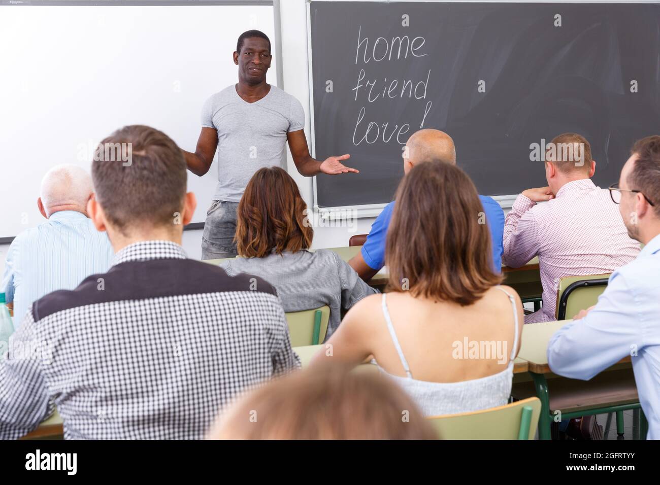 Young African American lecturer talking students Stock Photo - Alamy
