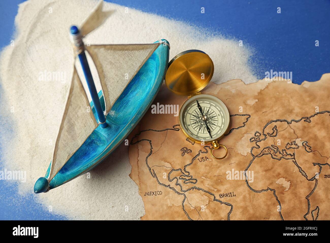 Wooden boat, compass and old map on blue background. Columbus Day ...