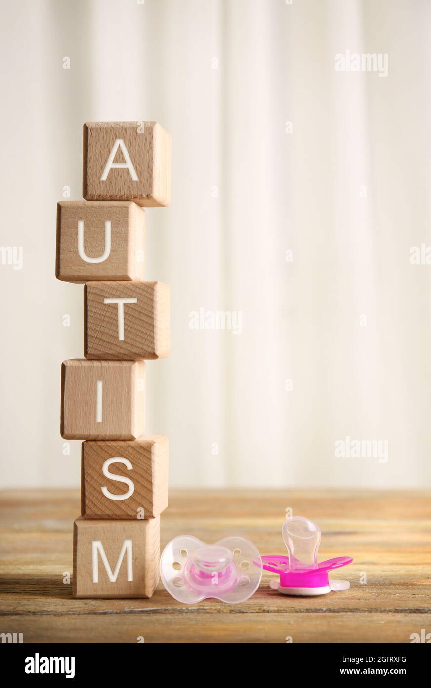 Wooden cubes with word autism and pacifiers on light background Stock ...