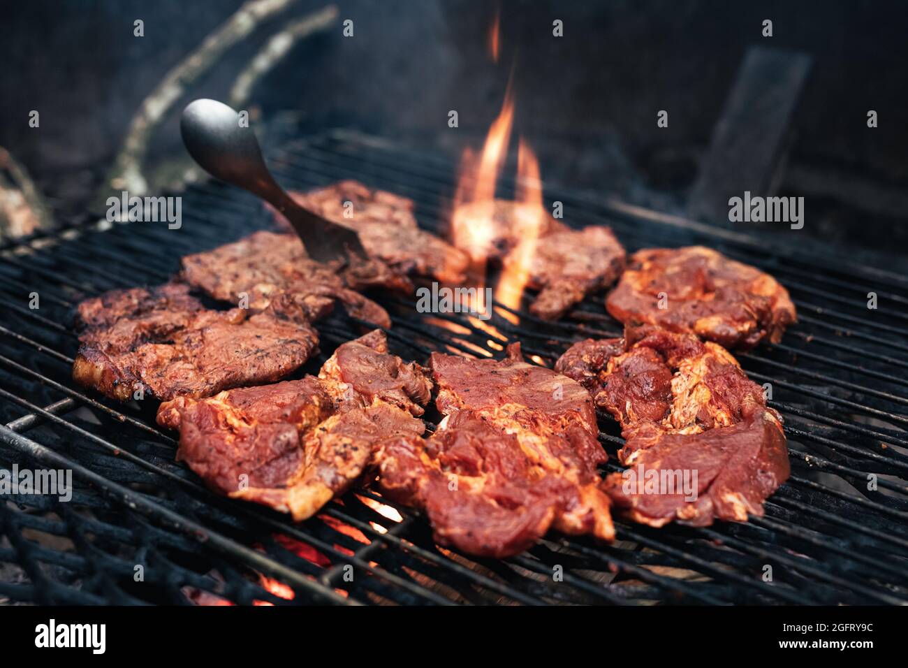 Cooking pork chops over an open fire Stock Photo - Alamy
