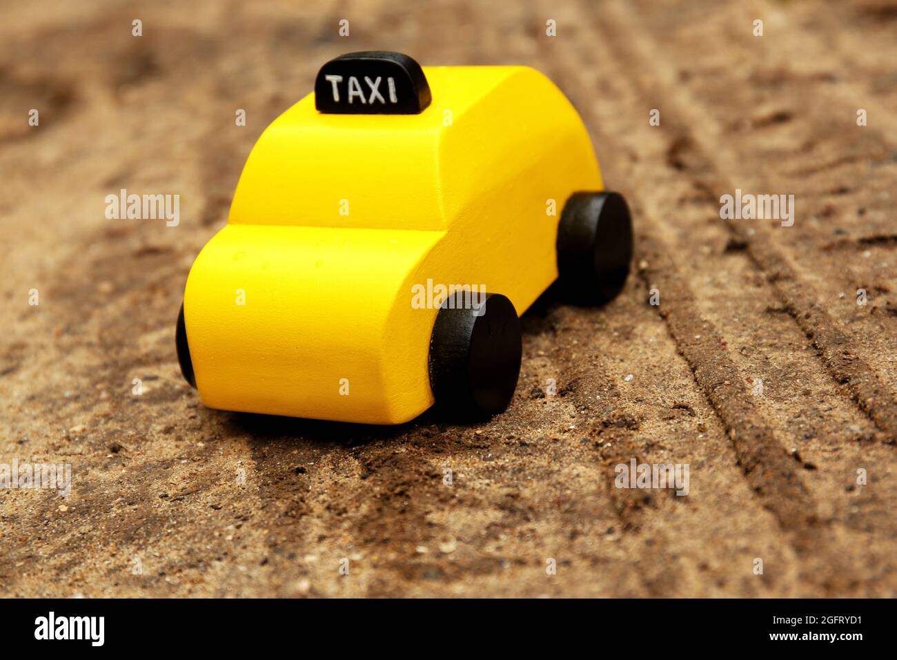 Yellow toy taxi cab on the ground Stock Photo - Alamy